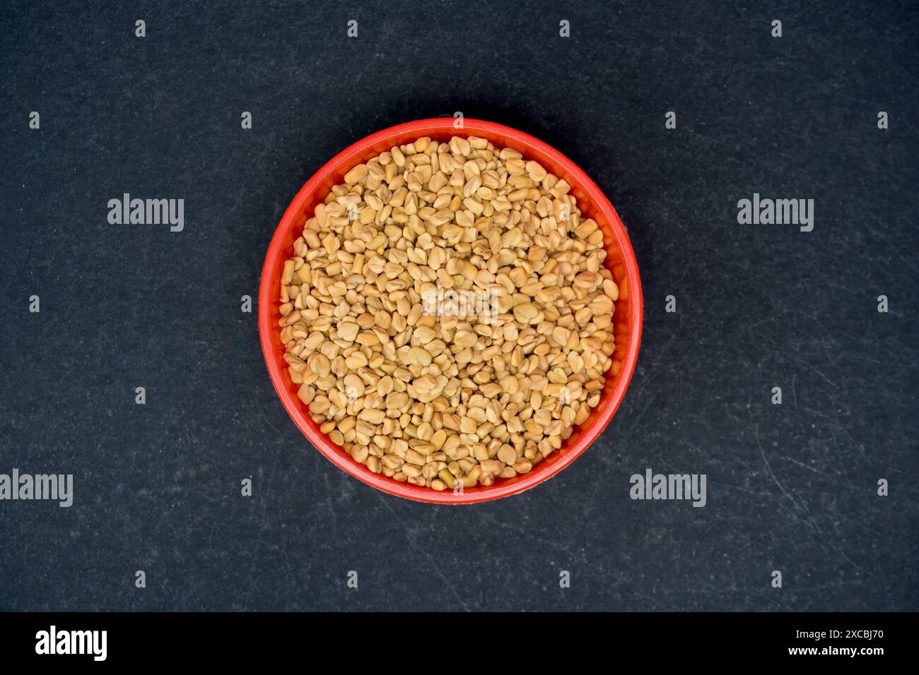 top view of Fenugreek Split seeds, known as Methi Kuria in red bowl ...