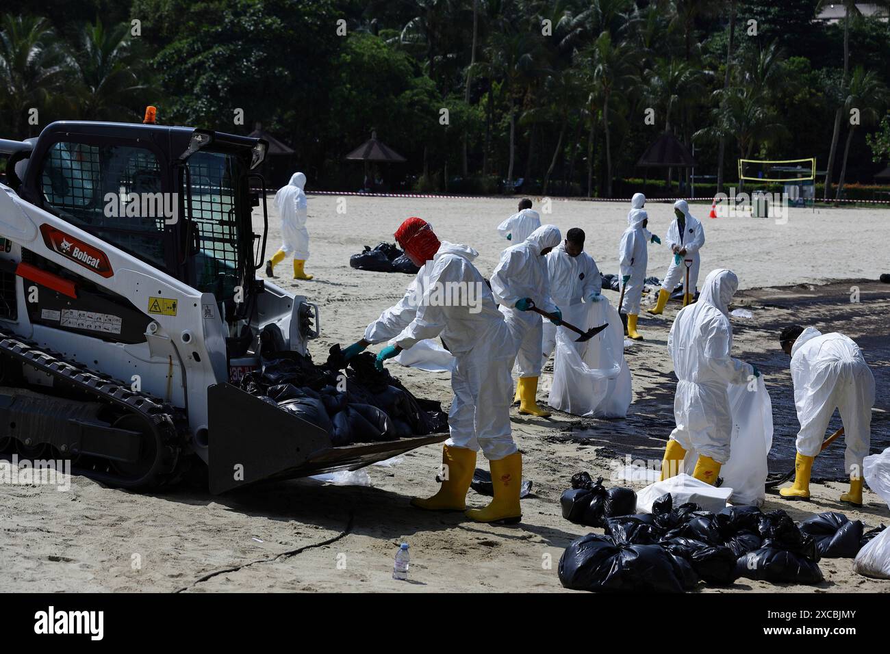 Workers clean oil spill along Sentosa's Tanjong Beach area in Singapore ...