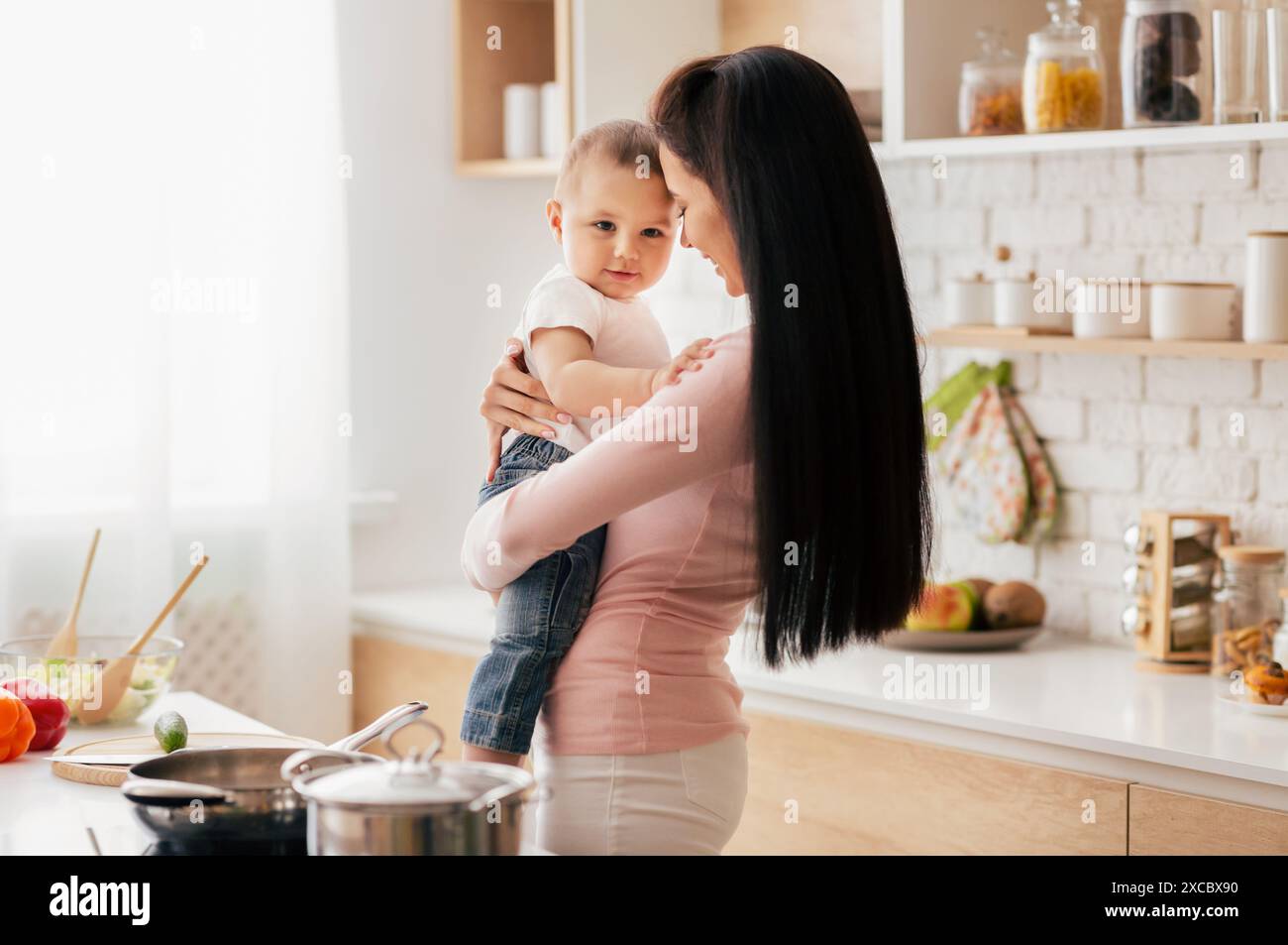 Mother cooking carrying baby in hi-res stock photography and images - Alamy