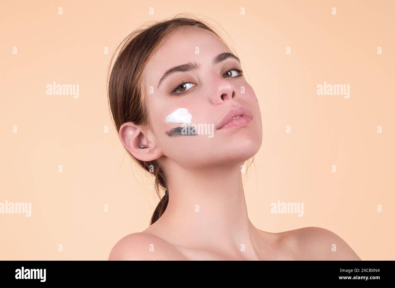 Young woman applying body cream against studio background. Beauty ...