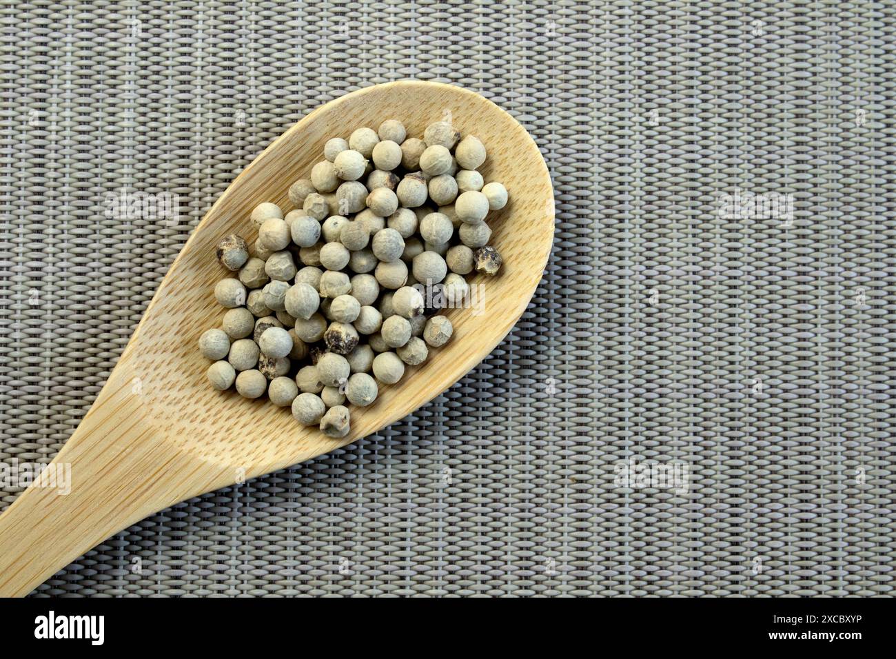 Spices, white peppers, pepper seeds sprinkled on white textured ...