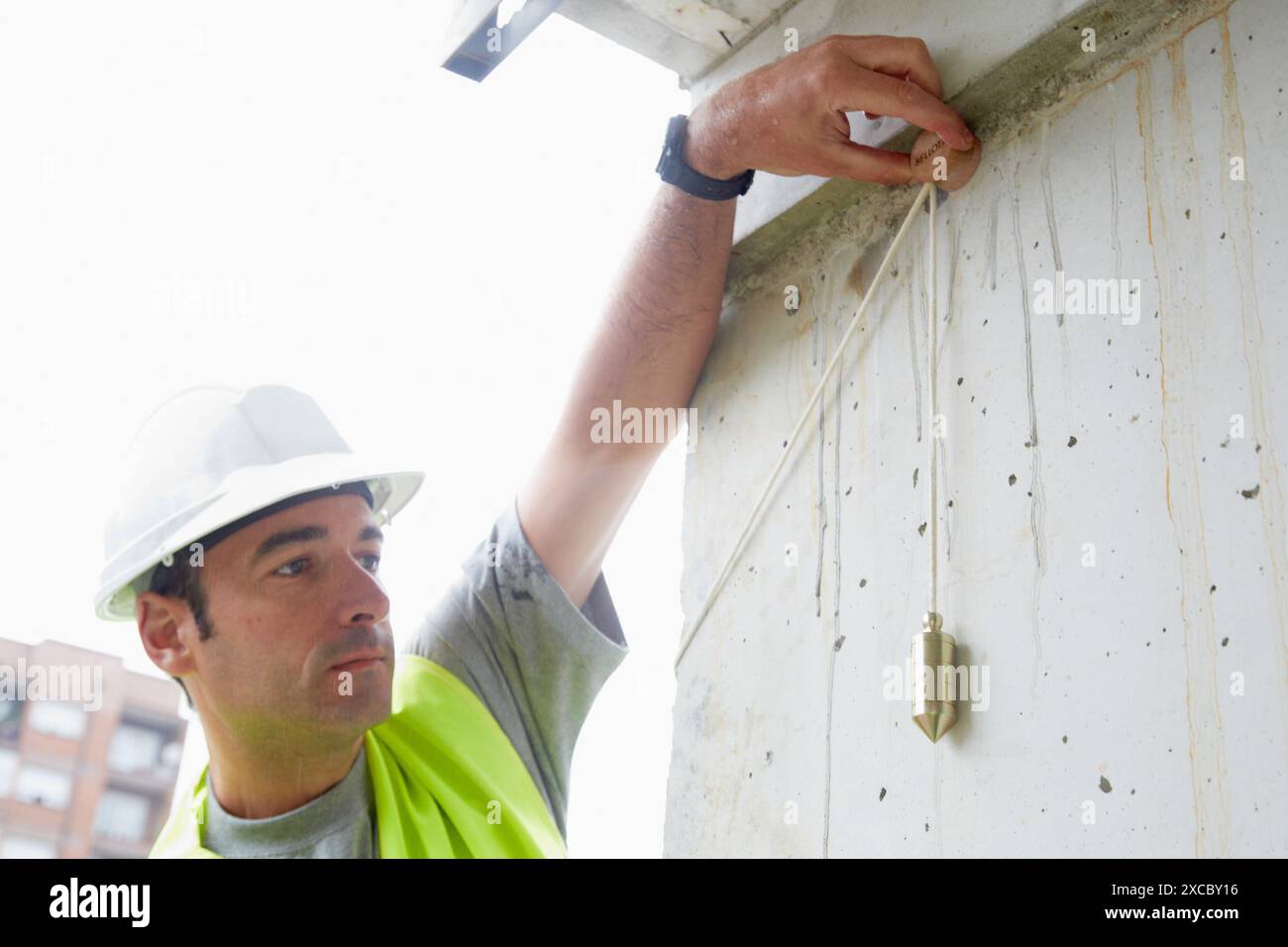 Worker with protective equipment, PPE, Checking and aligning vertical ...