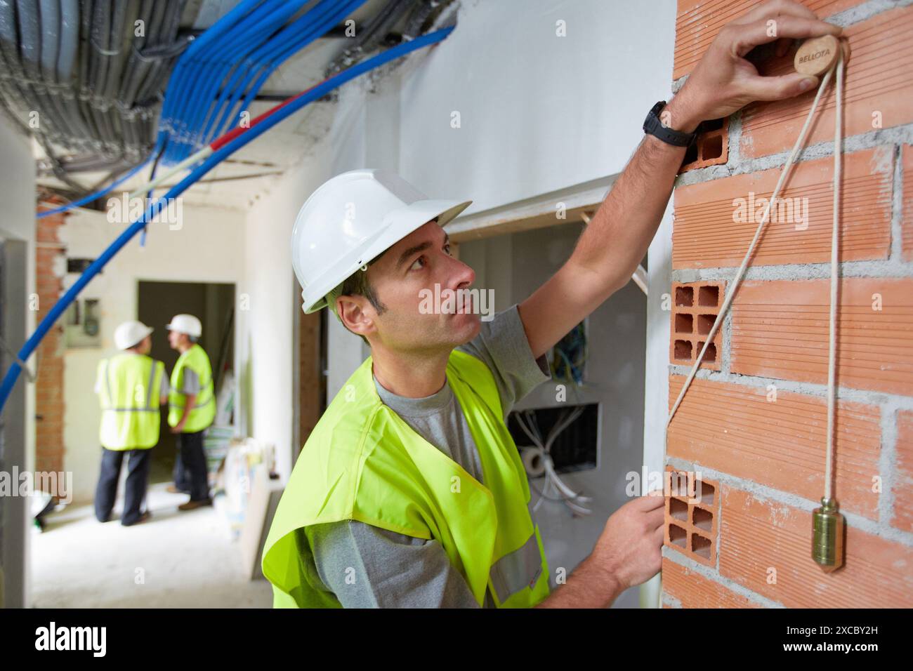 Worker with protective equipment, PPE, Checking and aligning vertical ...