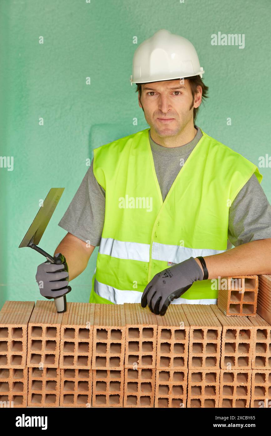 Bricklayer with trowel making a brick wall, Mason with personal ...