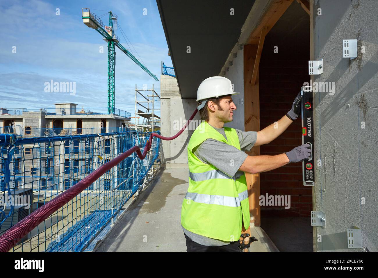 Mason checking the level of a wall, Bricklayer with personal protective ...