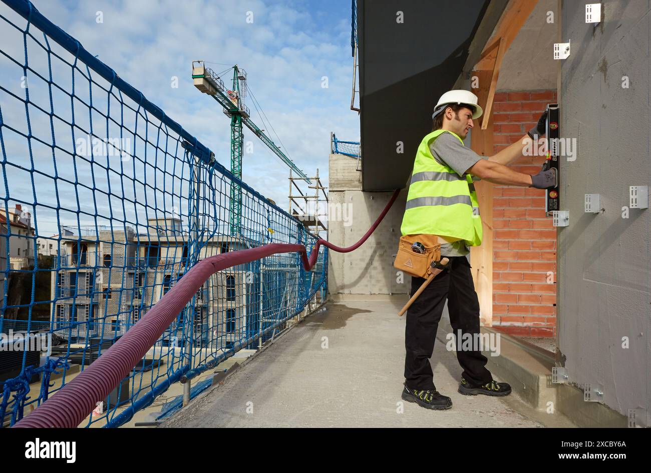 Mason checking the level of a wall, Bricklayer with personal protective ...