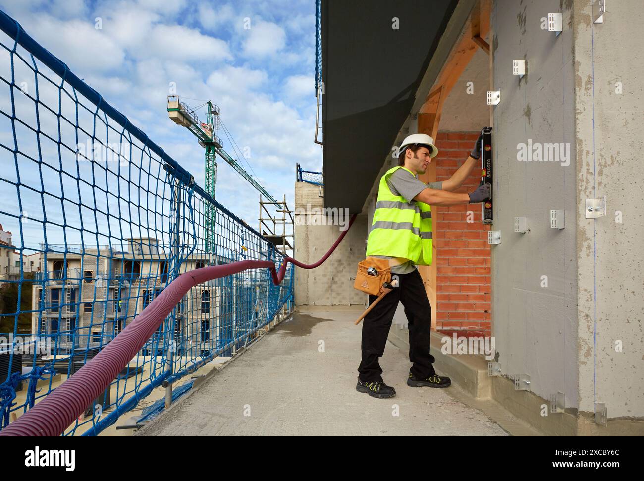 Mason checking the level of a wall, Bricklayer with personal protective ...