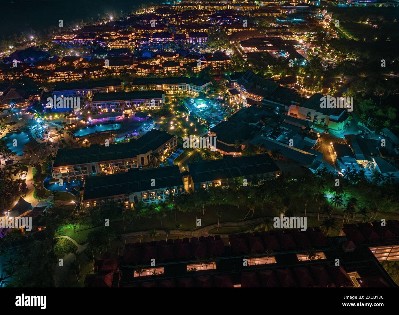 An Aerial view of a vibrant resort at night with illuminated buildings ...