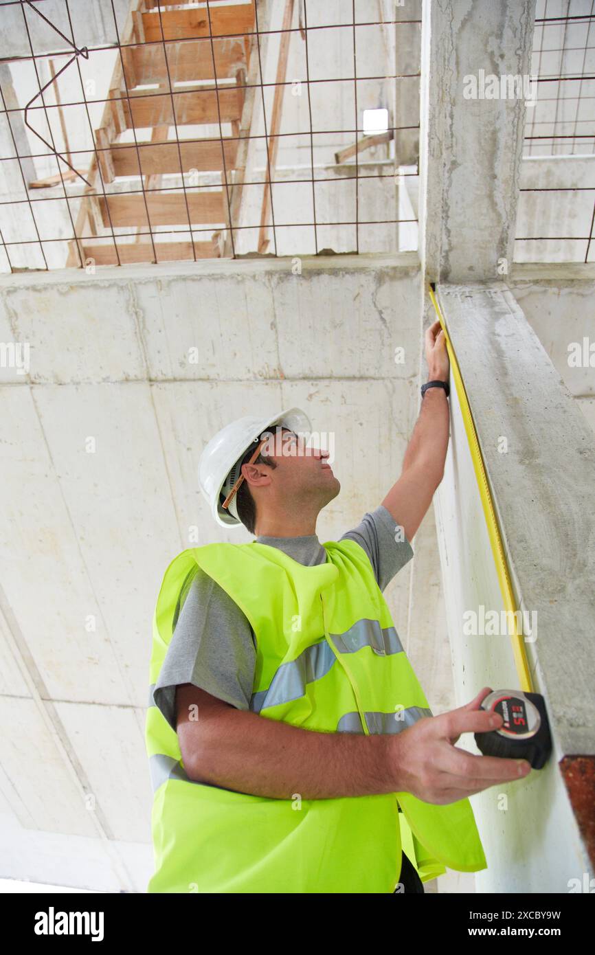 Worker with protective equipment, PPE, Taking measures in concrete beam ...