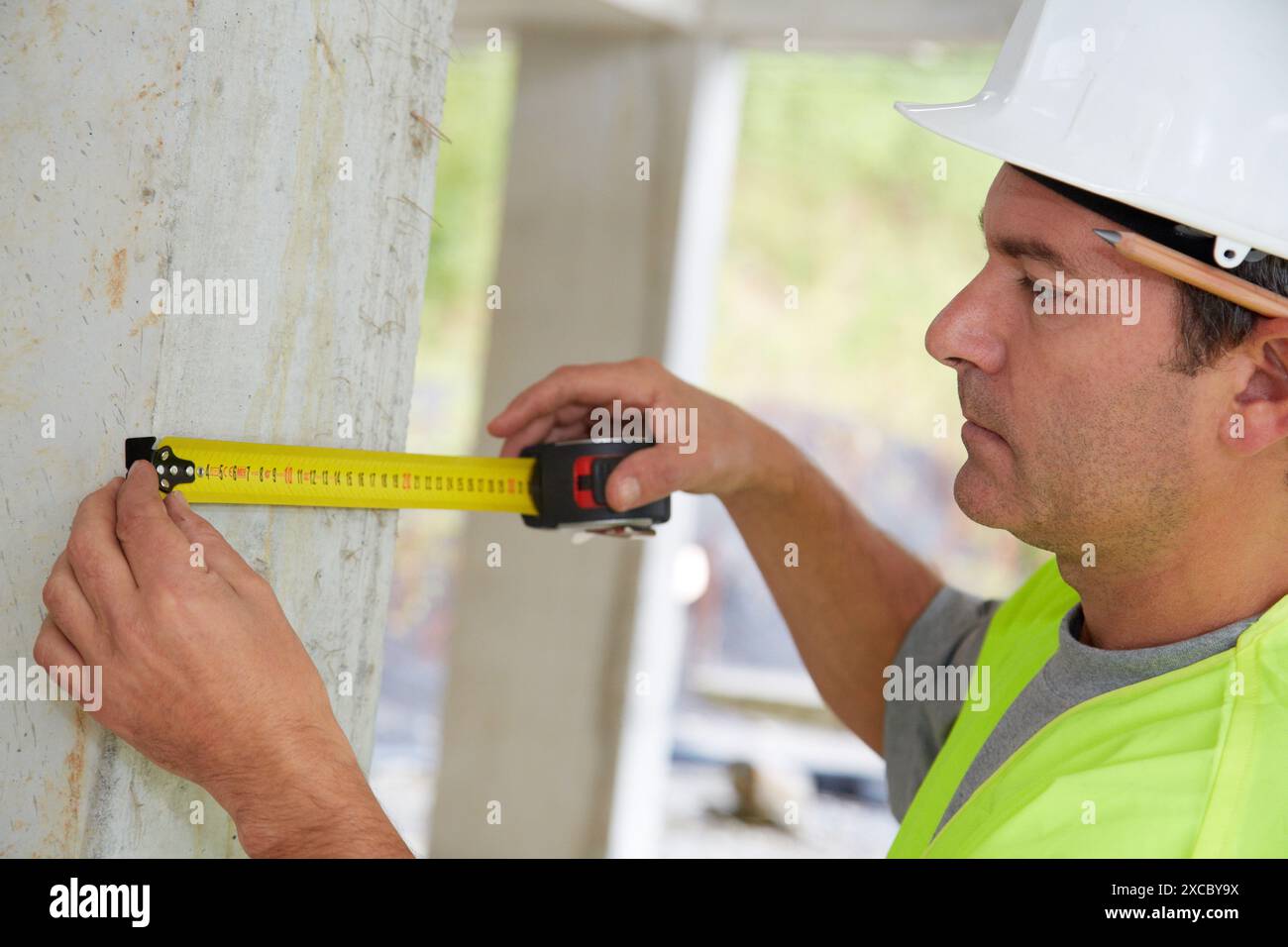Worker with protective equipment, PPE, Taking measures in concrete beam ...