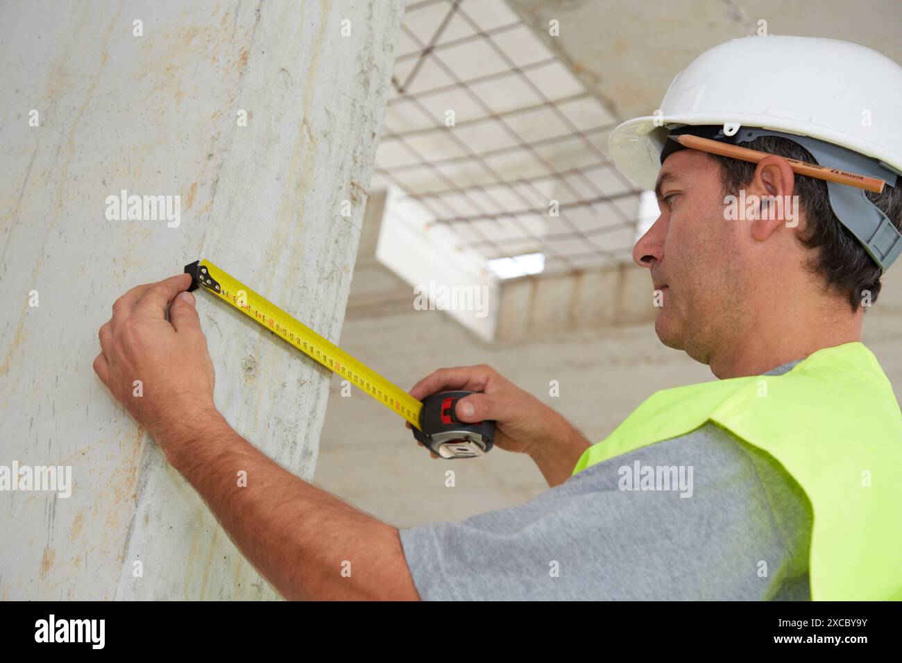 Worker with protective equipment, PPE, Taking measures in concrete beam ...