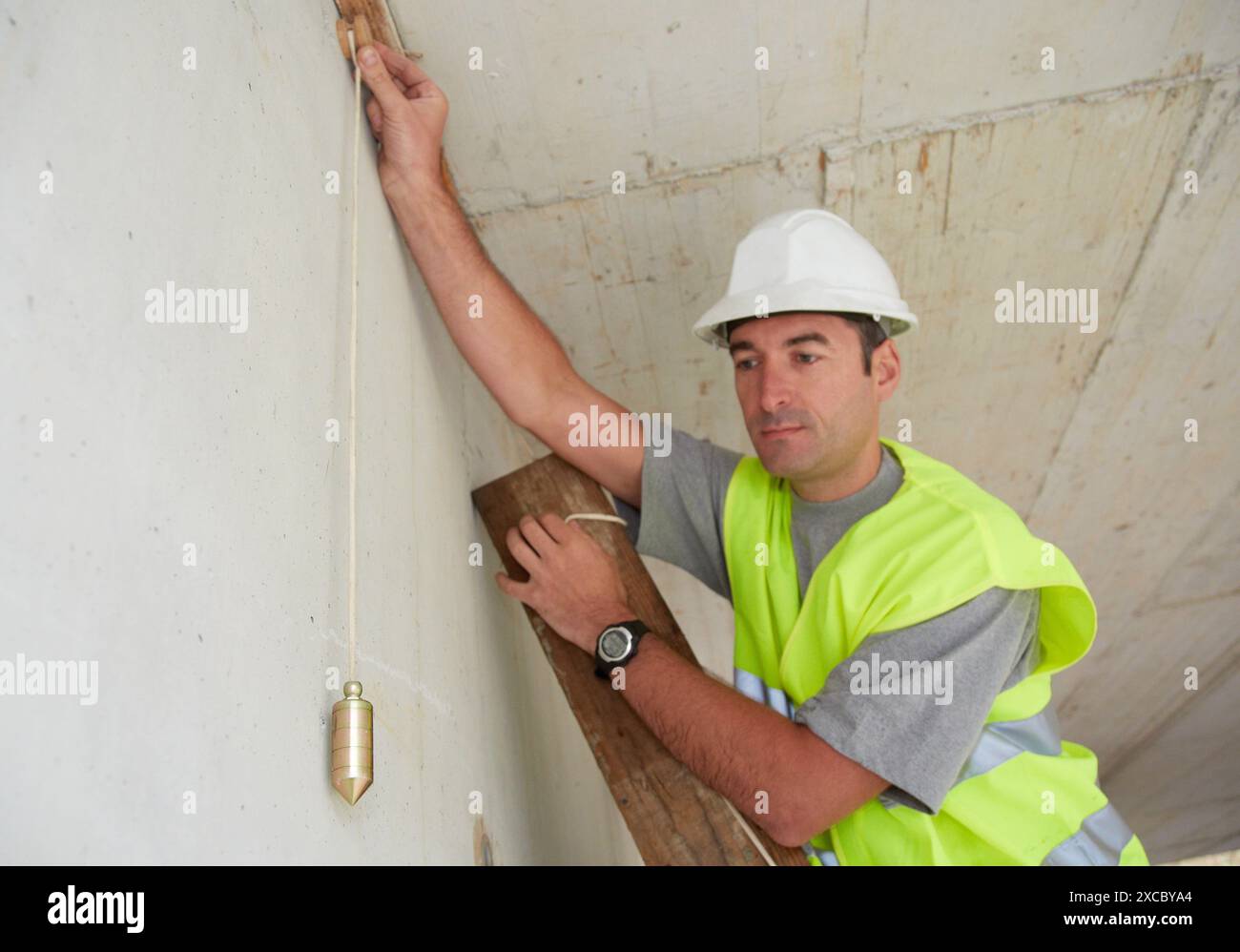 Worker with protective equipment, PPE, Checking and aligning vertical ...