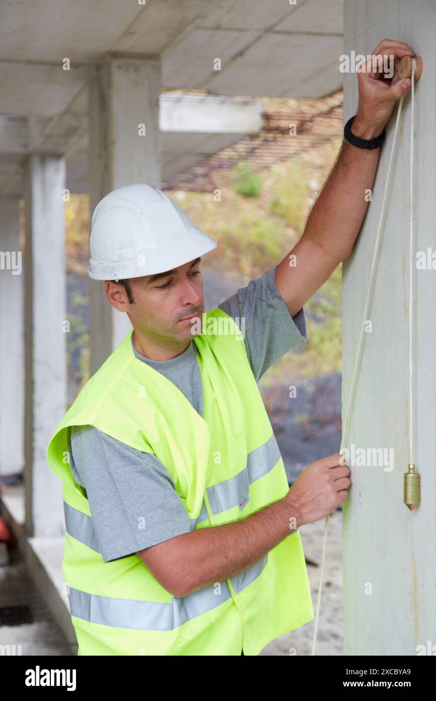 Worker with protective equipment, PPE, Checking and aligning vertical ...