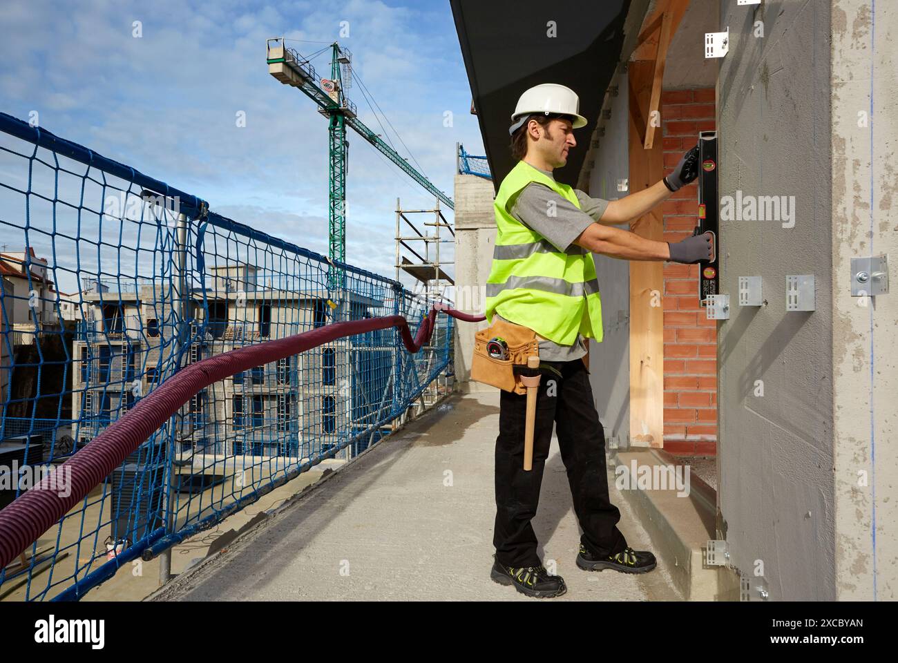Mason checking the level of a wall, Bricklayer with personal protective ...