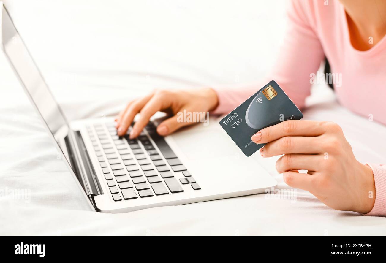 Woman Laying on Bed Using Laptop and Holding Credit Card Stock Photo ...