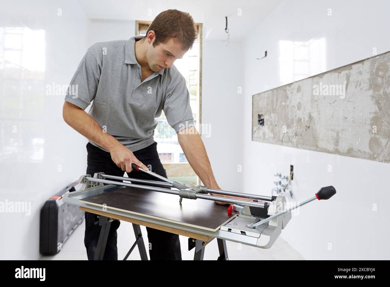 Bricklayer cutting tile. Manual tile cutter. Construction Industry ...