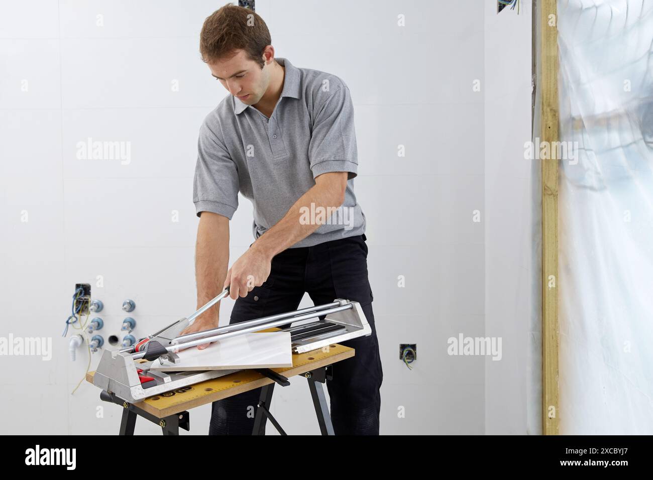 Bricklayer cutting tile. Manual tile cutter. Construction Industry ...