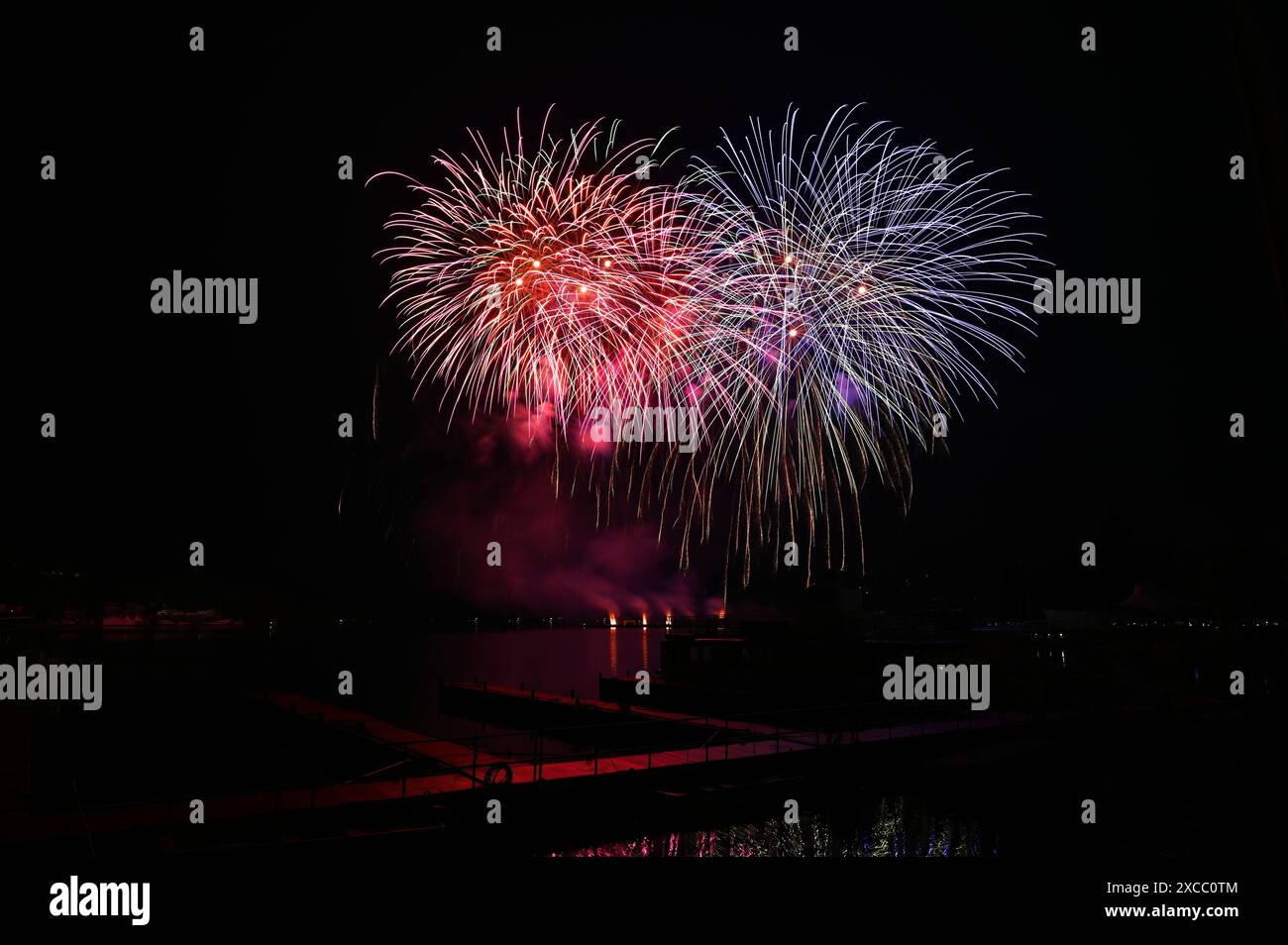 Firework. Beautiful colorful fireworks on the water surface with a ...