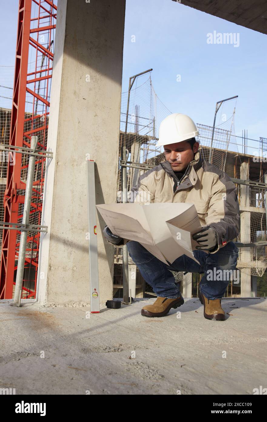Construction worker looking at blueprints, personal protective ...