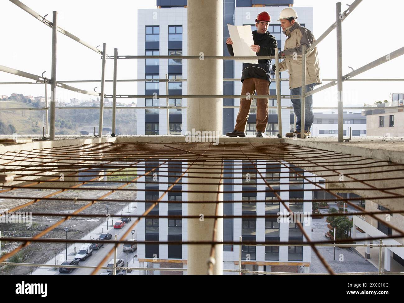 Architect and construction worker looking at blueprints, personal ...