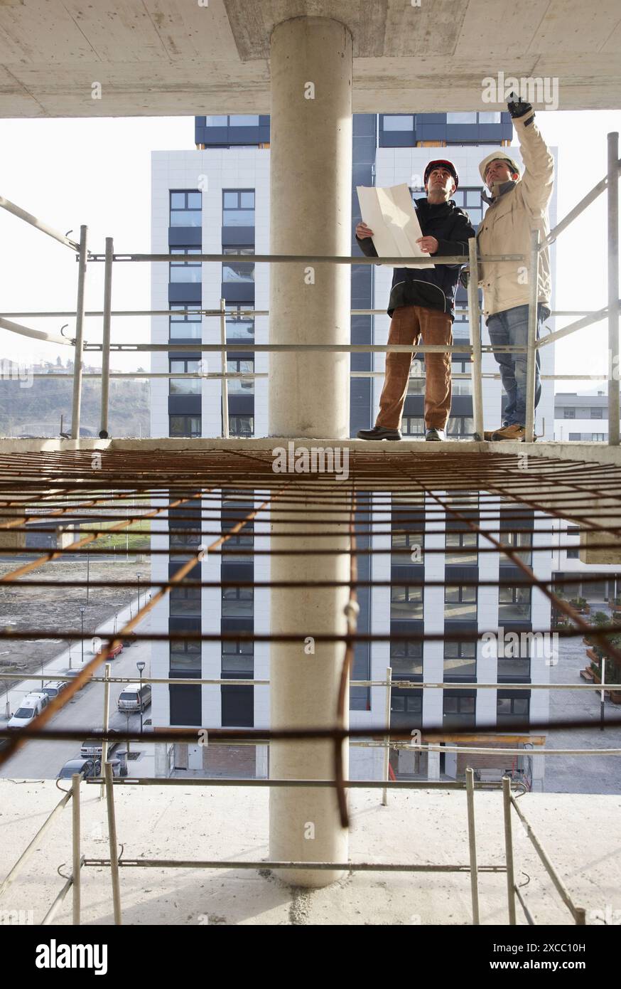 Architect and construction worker looking at blueprints, personal ...