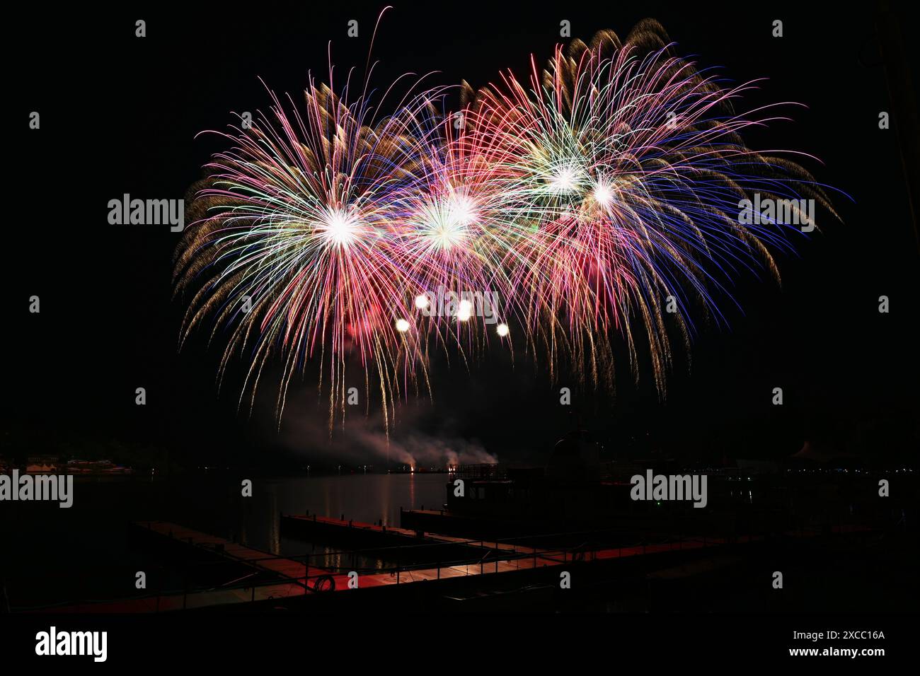 Firework. Beautiful colorful fireworks on the water surface with a ...