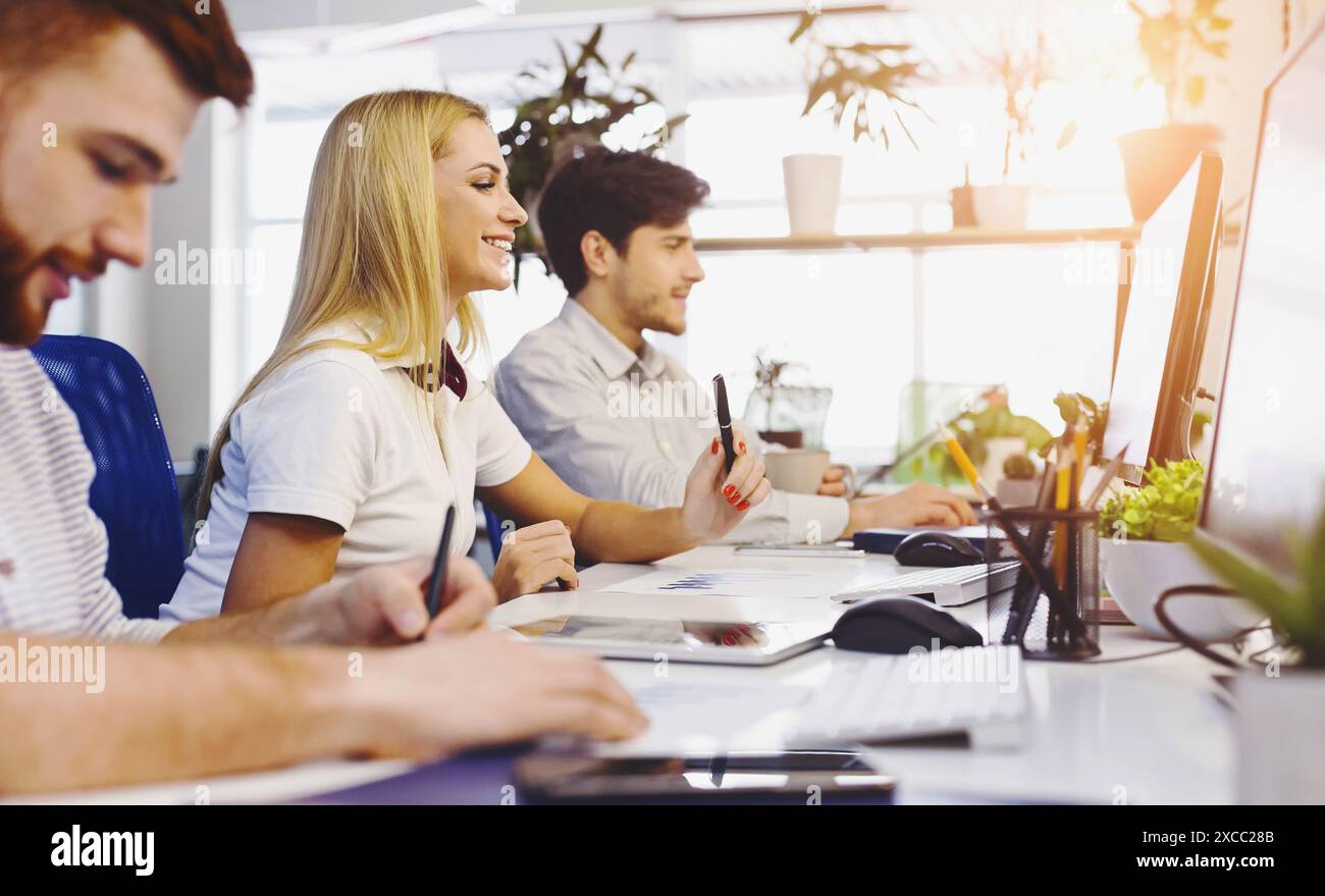 Group of People Sitting at Desk in Front of Computer Stock Photo - Alamy