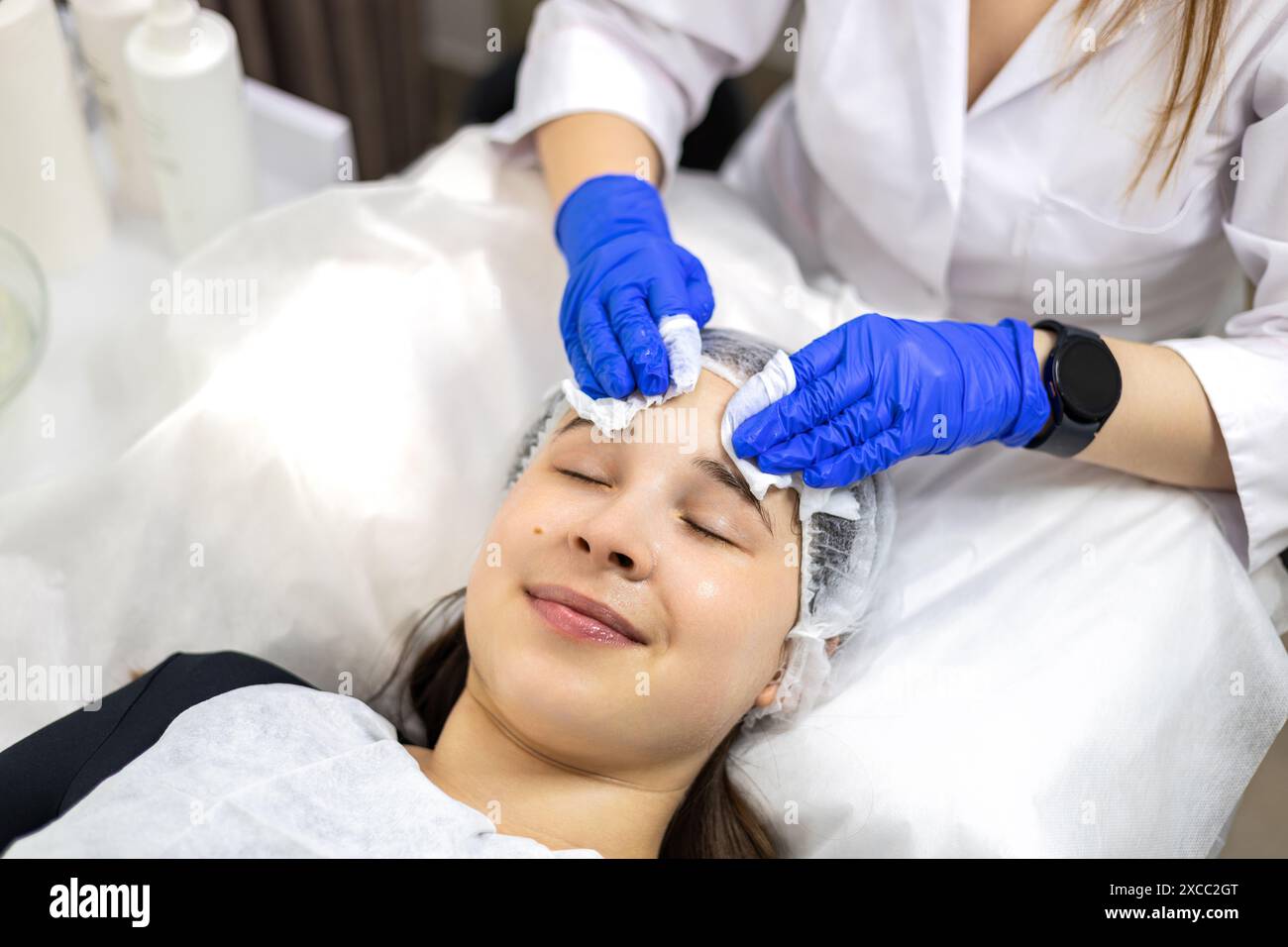 Cosmetologist in nitrile gloves removing the remains of gel from the ...