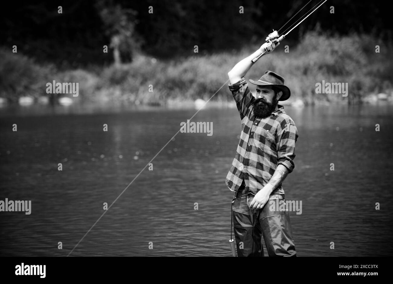 Fisherman fishing on a rever. Relaxed fisher man with a fishing rod on ...