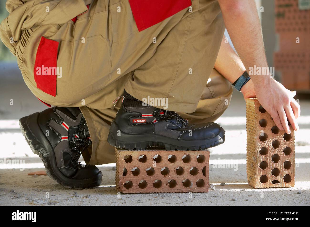 Bricklayer with safety boots, bricks, housing construction Stock Photo ...