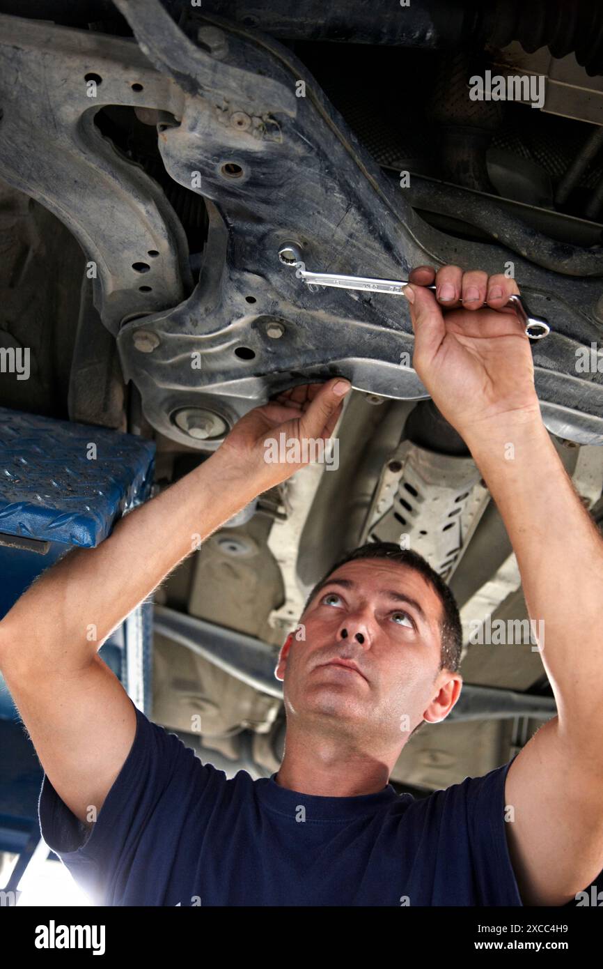 Worker using ring spanner in car repair shop Stock Photo - Alamy