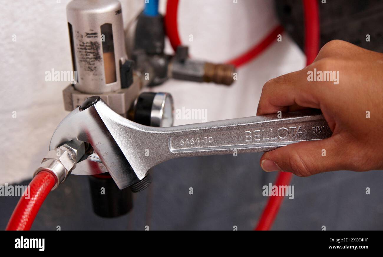 Worker using adjustable spanner in car repair shop Stock Photo - Alamy