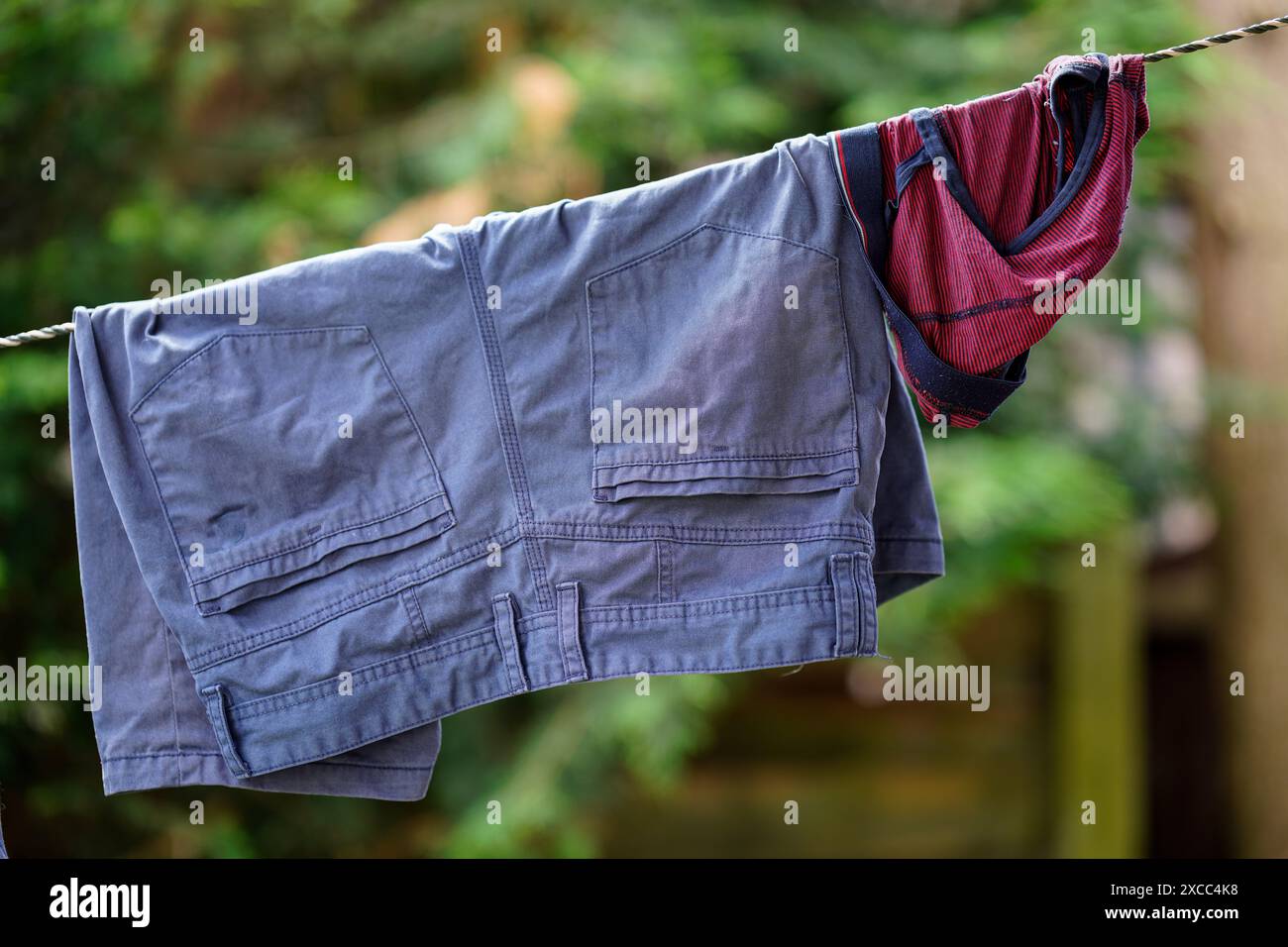 Blue cargo pants and red under wear hanging on a clothesline outdoors ...