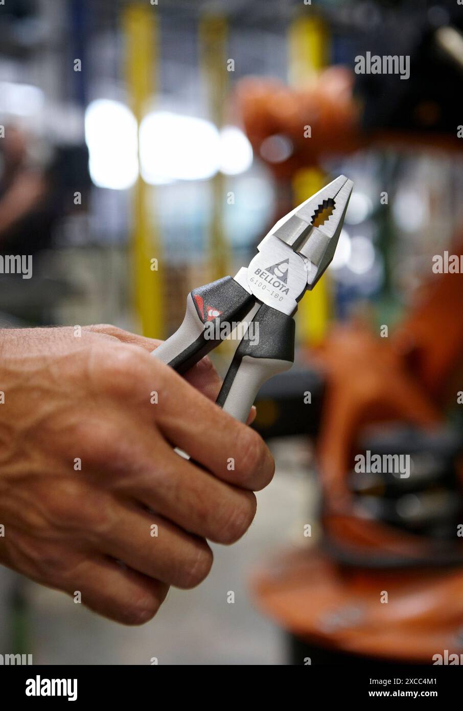 Hand holding pliers Stock Photo - Alamy