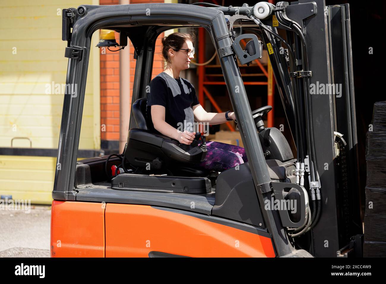 Woman 20-30 operating forklift in industrial setting, showcasing skills ...