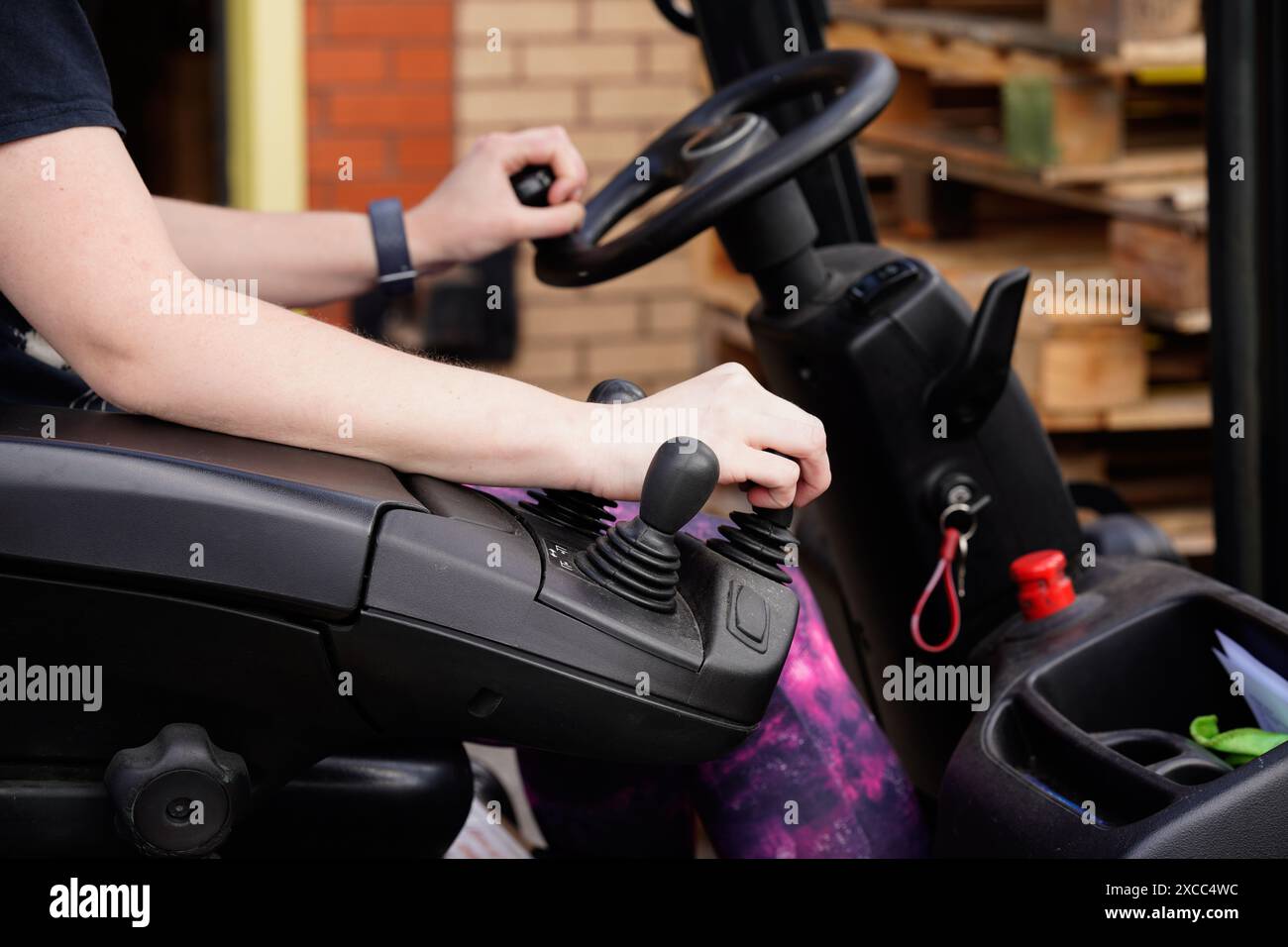 Forklift operator managing controls in an warehouse, highlighting ...