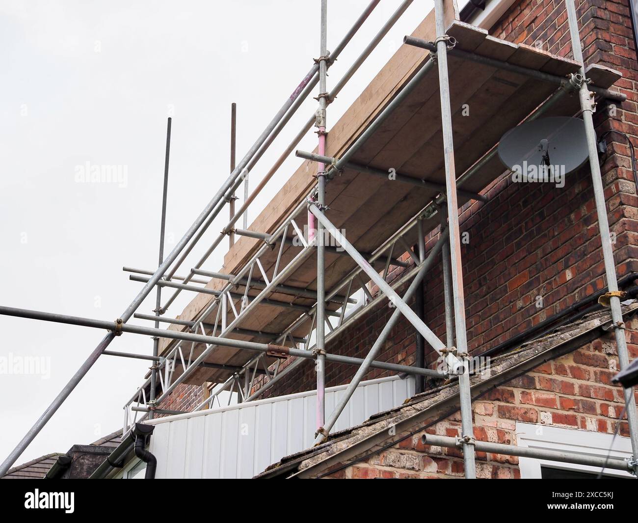 Scaffolding on brick building for construction with satellite dish ...