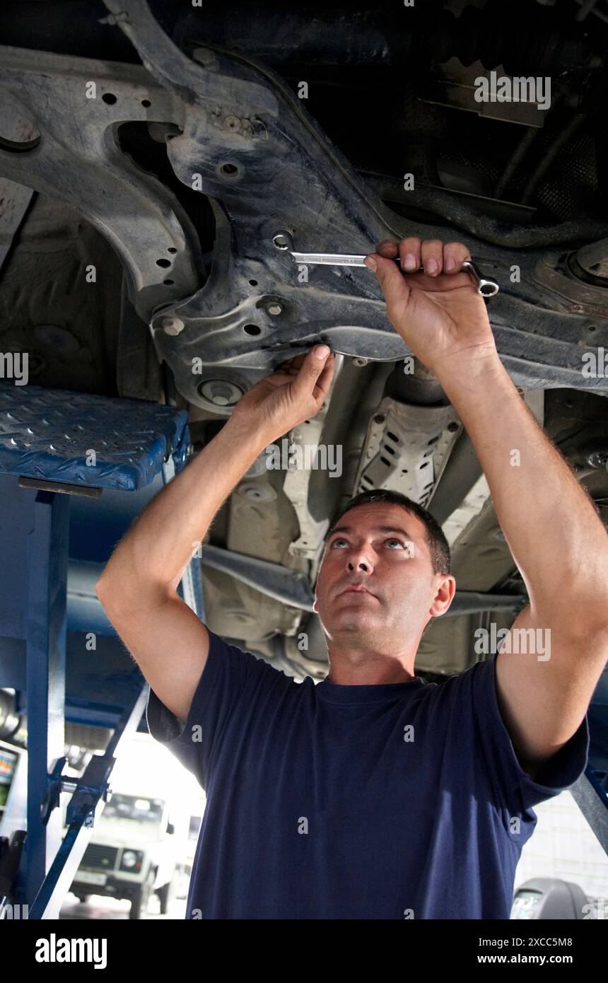 Worker using ring spanner in car repair shop Stock Photo - Alamy