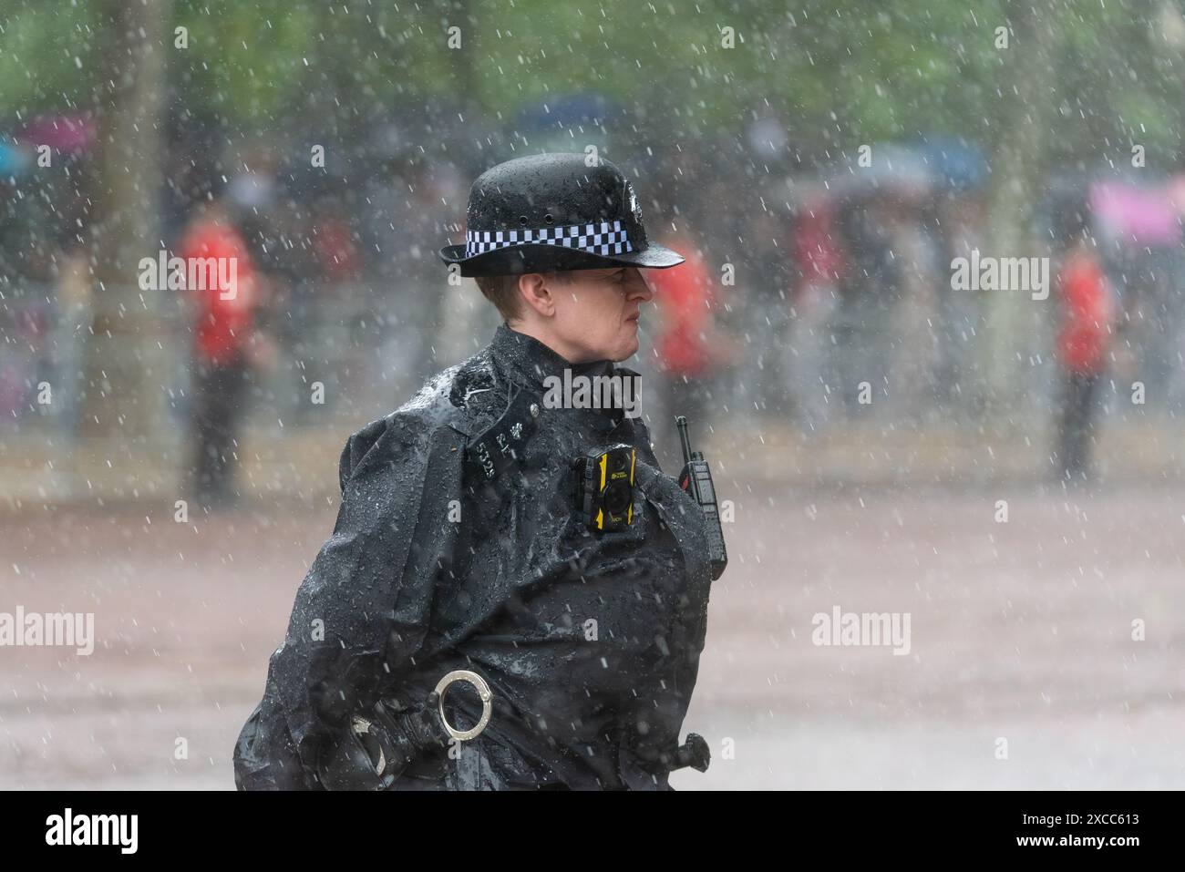 Female police officer getting wet during a heavy rain storm at Trooping ...