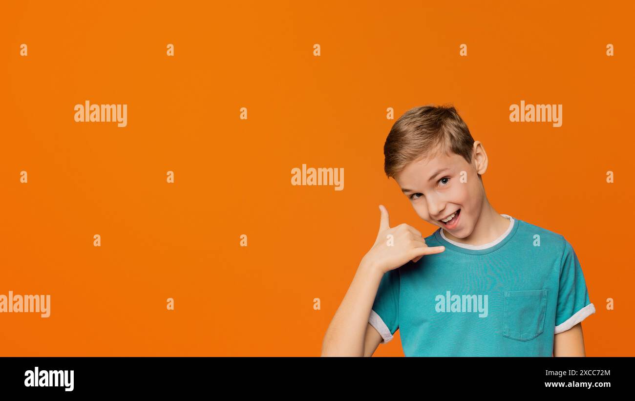 Flirty boy making call me gesture, orange background Stock Photo - Alamy