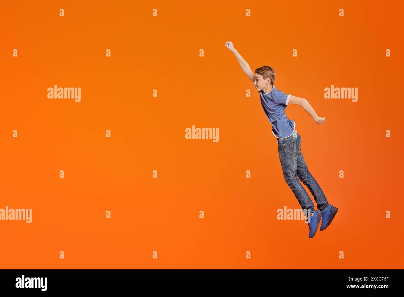 Little boy jumping with raised fist like superhero Stock Photo - Alamy