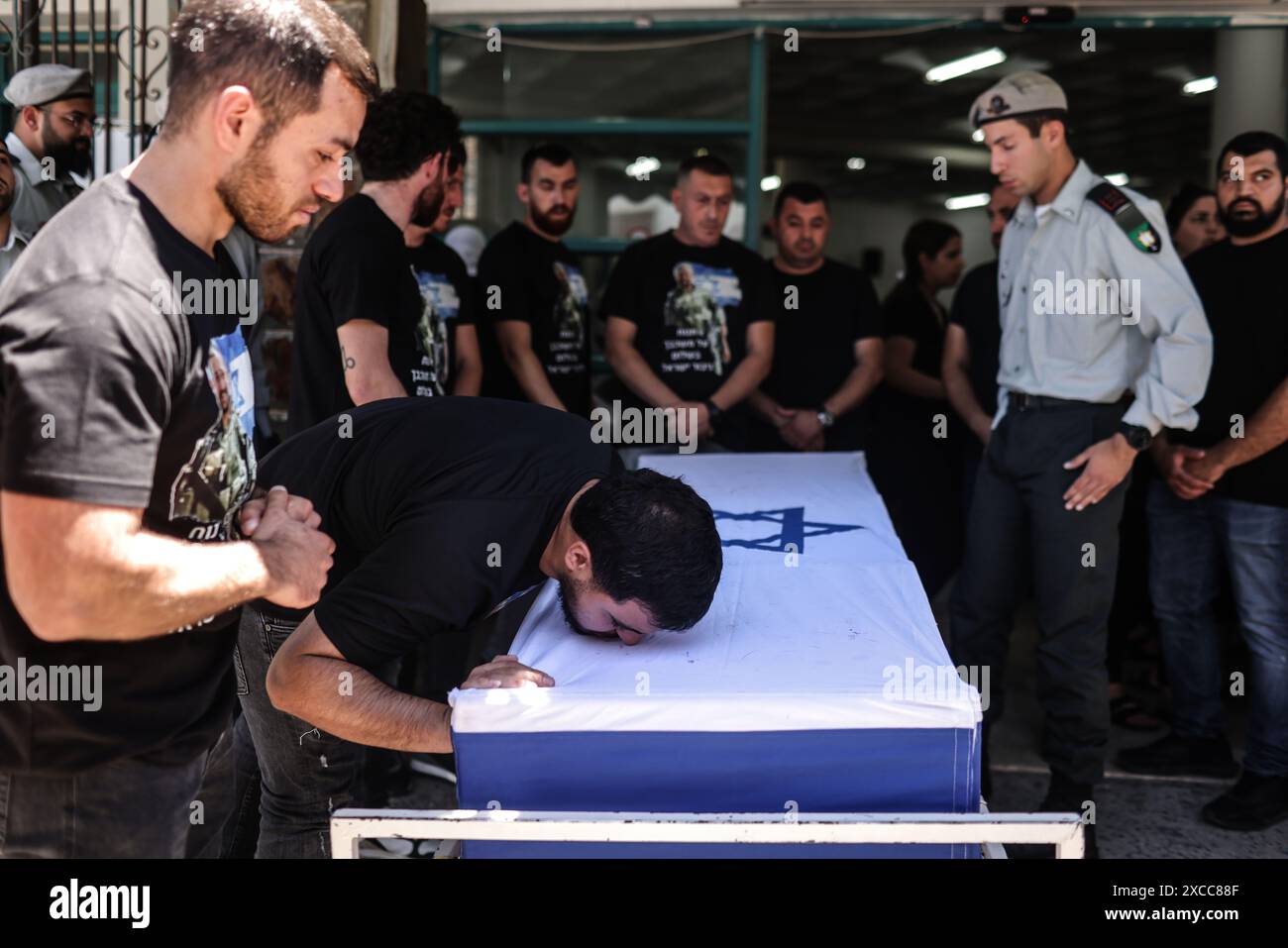 Beit Jann, Israel. 16th June, 2024. A man cries on the flag-draped ...