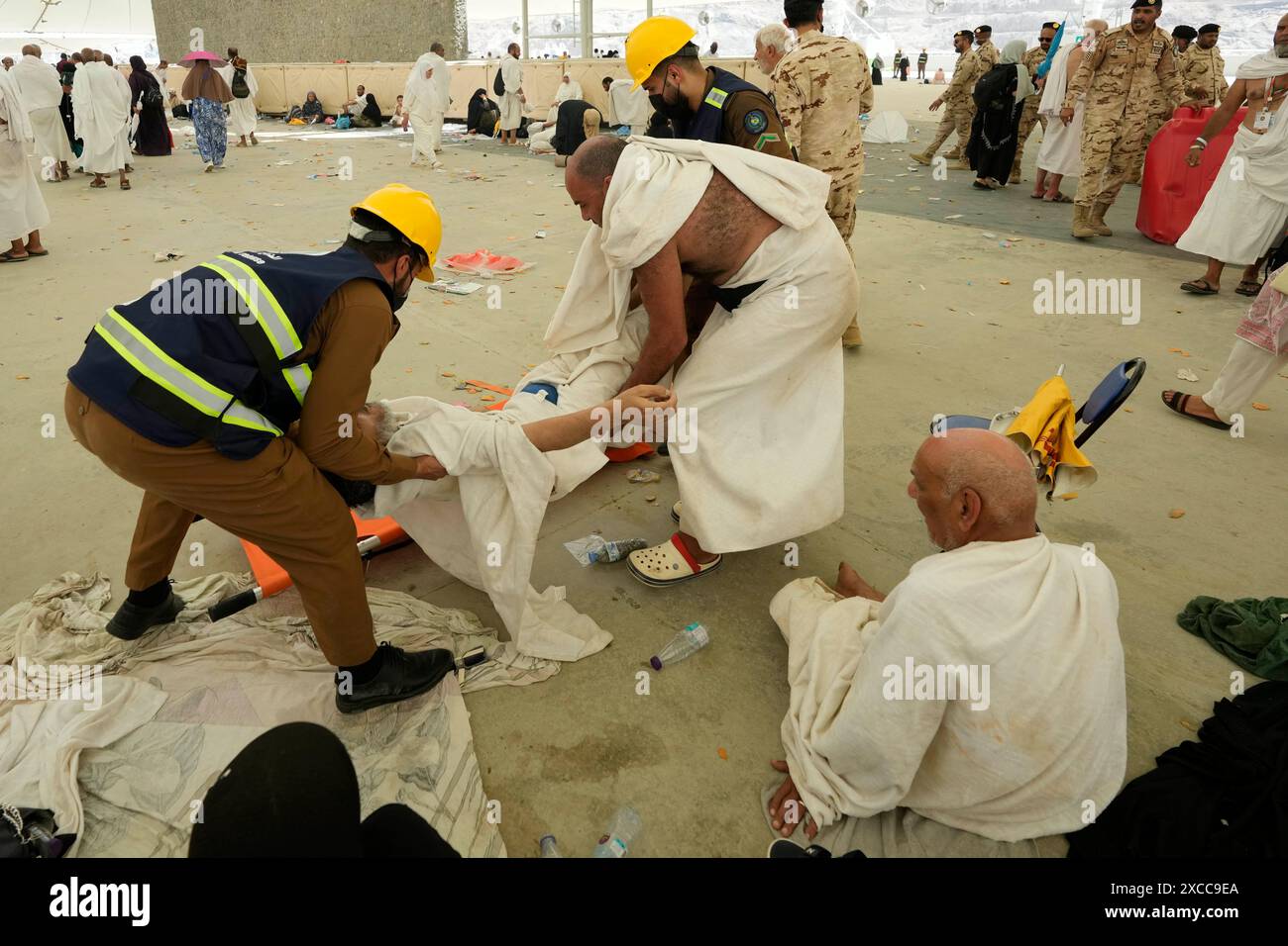 Paramedics carry a muslim pilgrim for a medical check after he fell ...