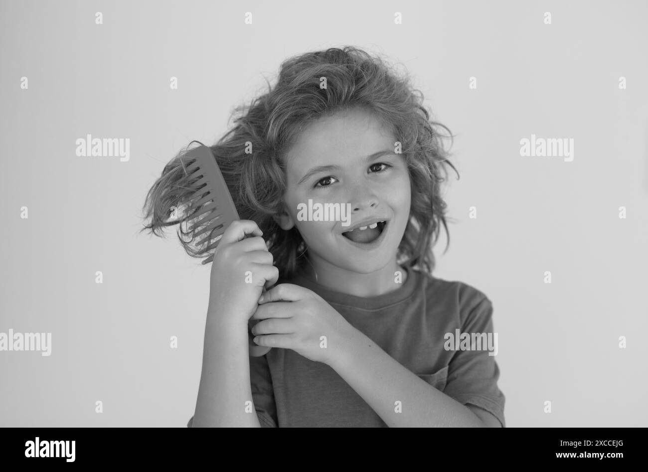 Funny kids hairstyle. Cute child with comb. Blonde kid combs unruly ...