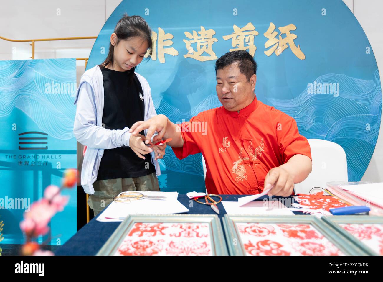 Shanghai, China. 16th June, 2024. A child learns paper cutting skills ...