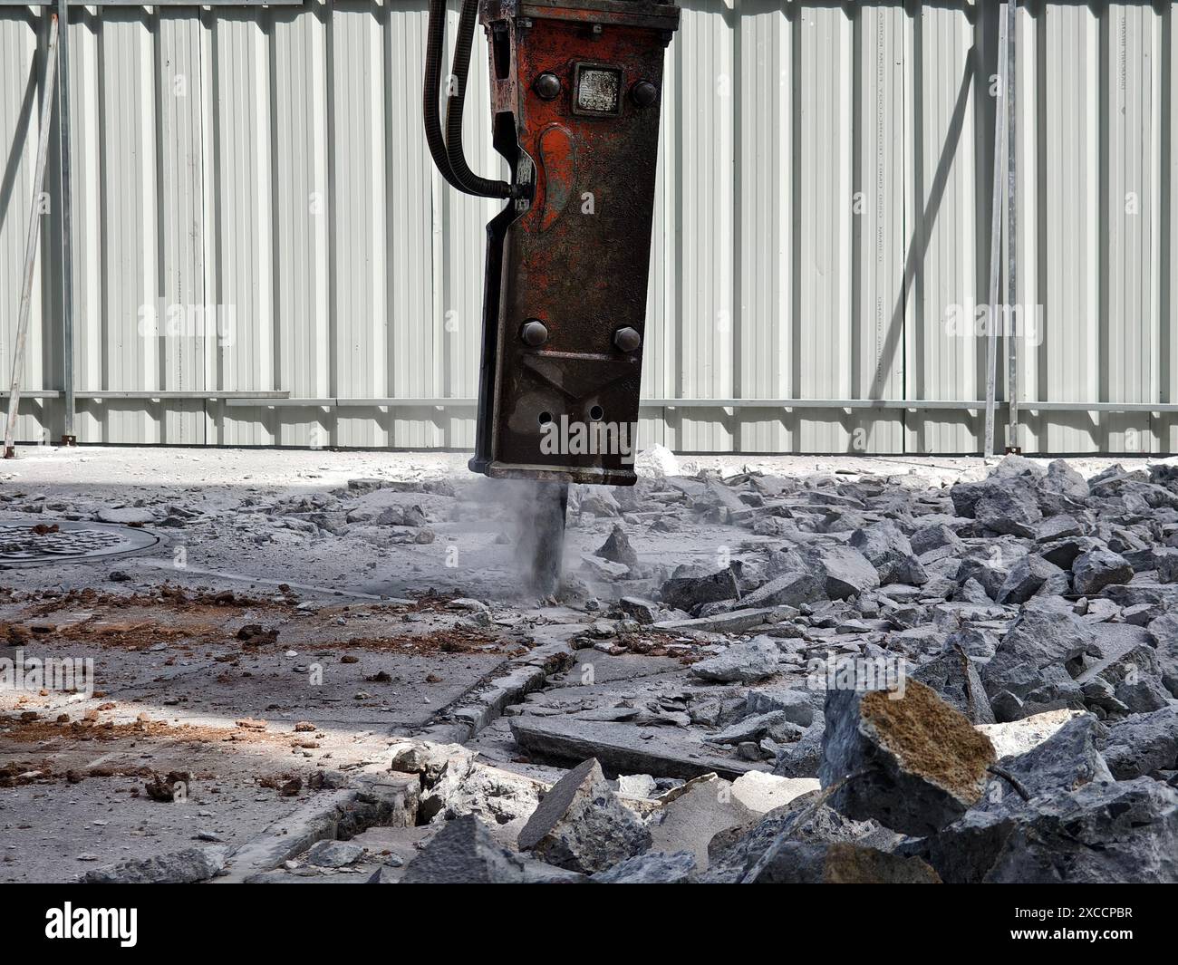 A hydraulic hammer breaking concrete at a construction site Stock Photo ...