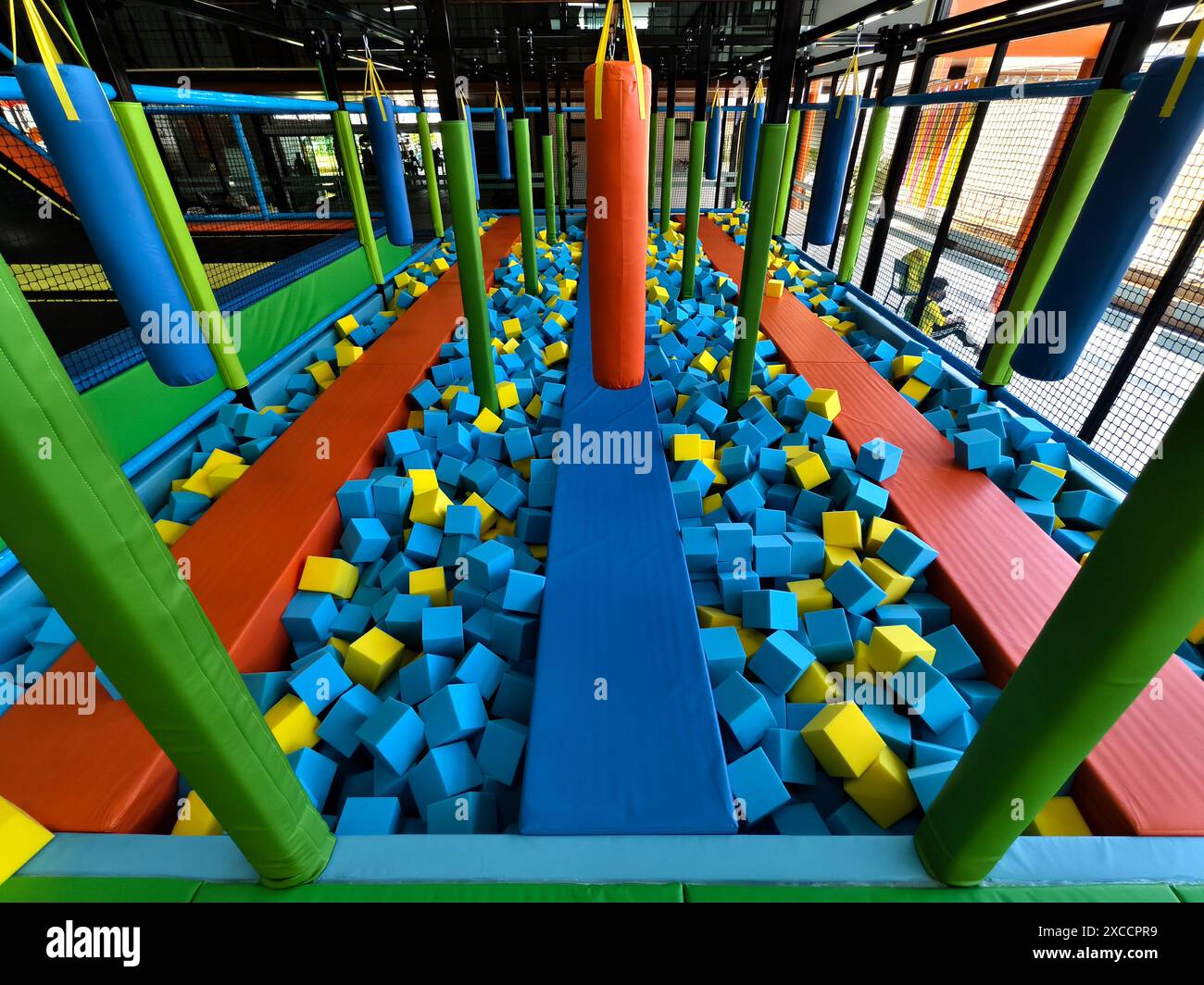 Trampoline park has blue and yellow foam cubes for kids fun Stock Photo ...