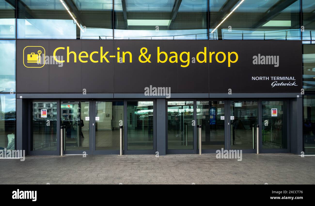 A large sign reading "check-in & bag drop" above an entrance to check ...