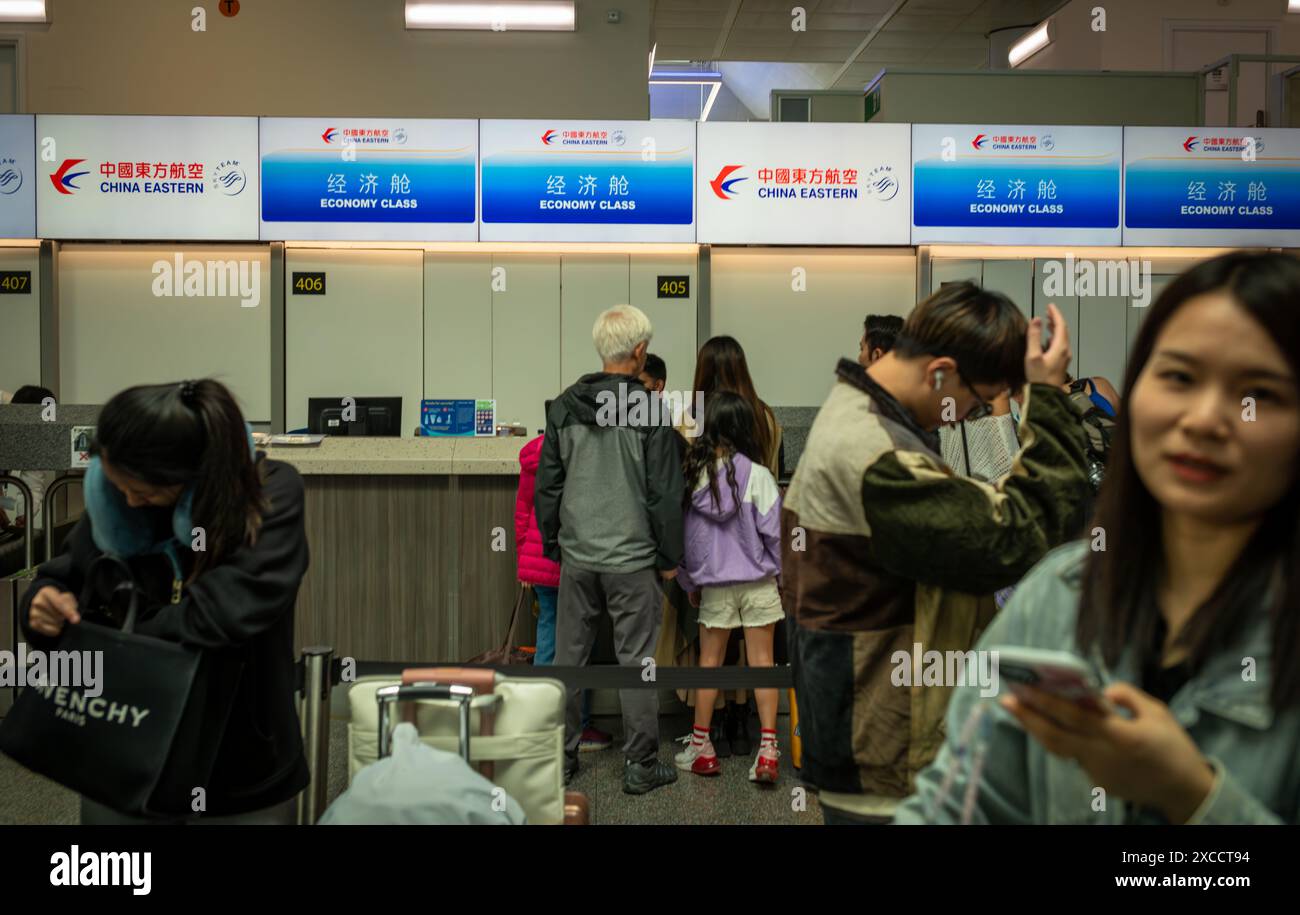 Chinese passengers queue to check in for a China Eastern flight to ...