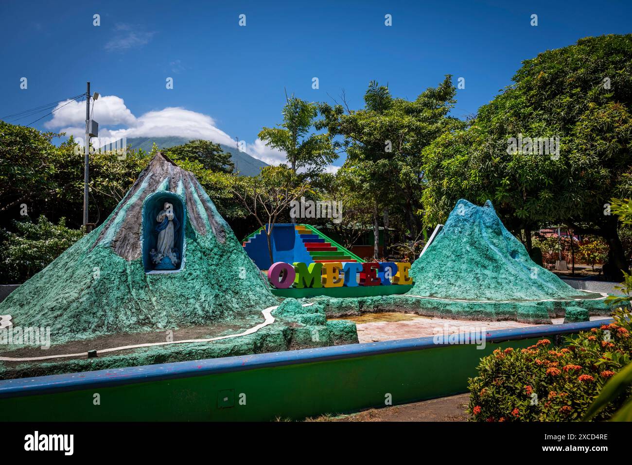 Virgin Mary statue in a volcano shaped structure and real volcano ...